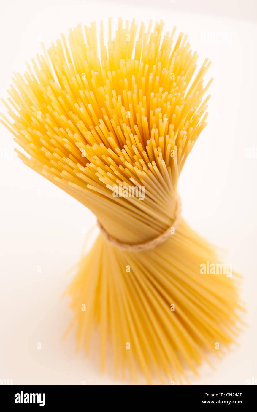 Wheat spaghetti standing tied with rope in bundle, isolated over white ...