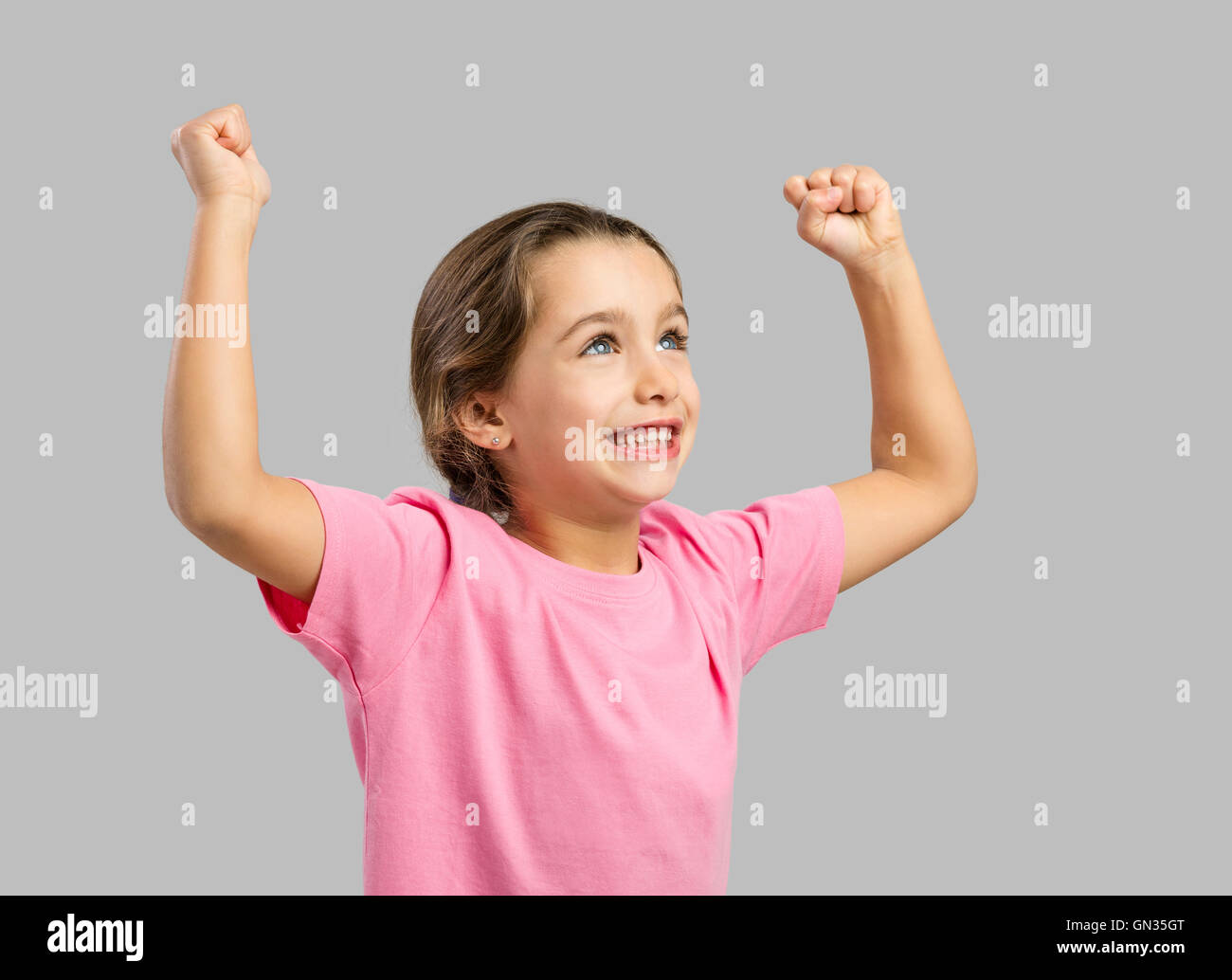 Studio portrait of a happy little girl with arms raised on air Stock ...