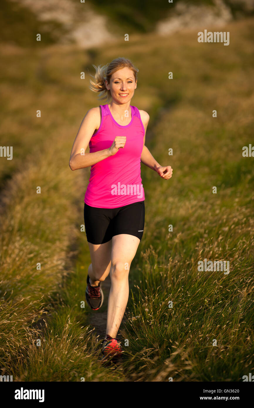 beautiful young woman runns on a mountian path at sunrise Stock Photo ...