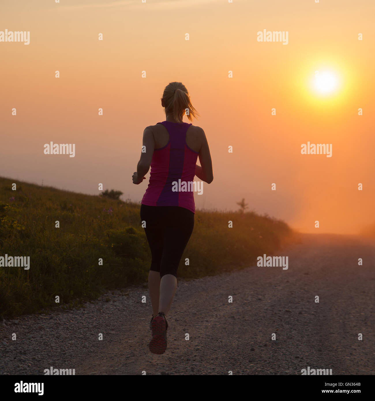 beautiful young woman runns on a mountian path at sunrise Stock Photo ...