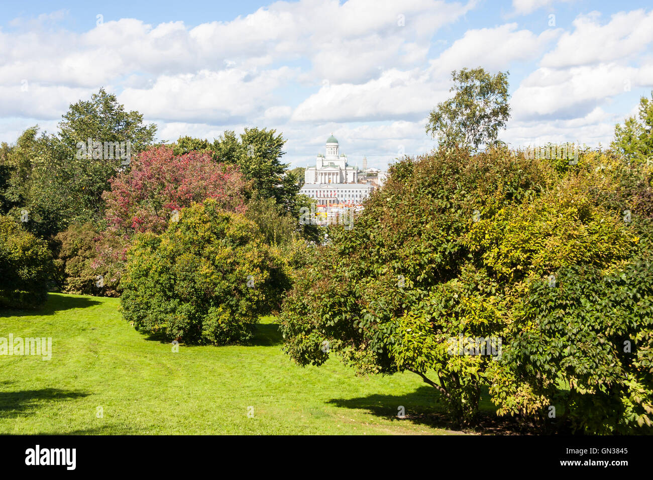 White St. Nicholas church behind trees in Helsinki, Finland Stock Photo ...