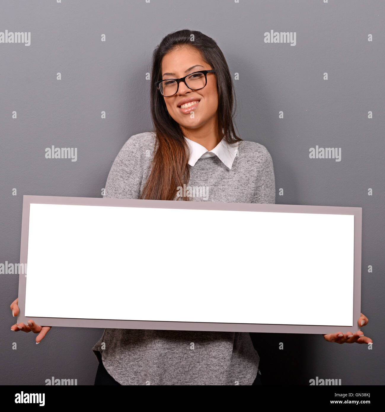 Portrait of smiling woman holding blank sign board.Studio portrait of ...