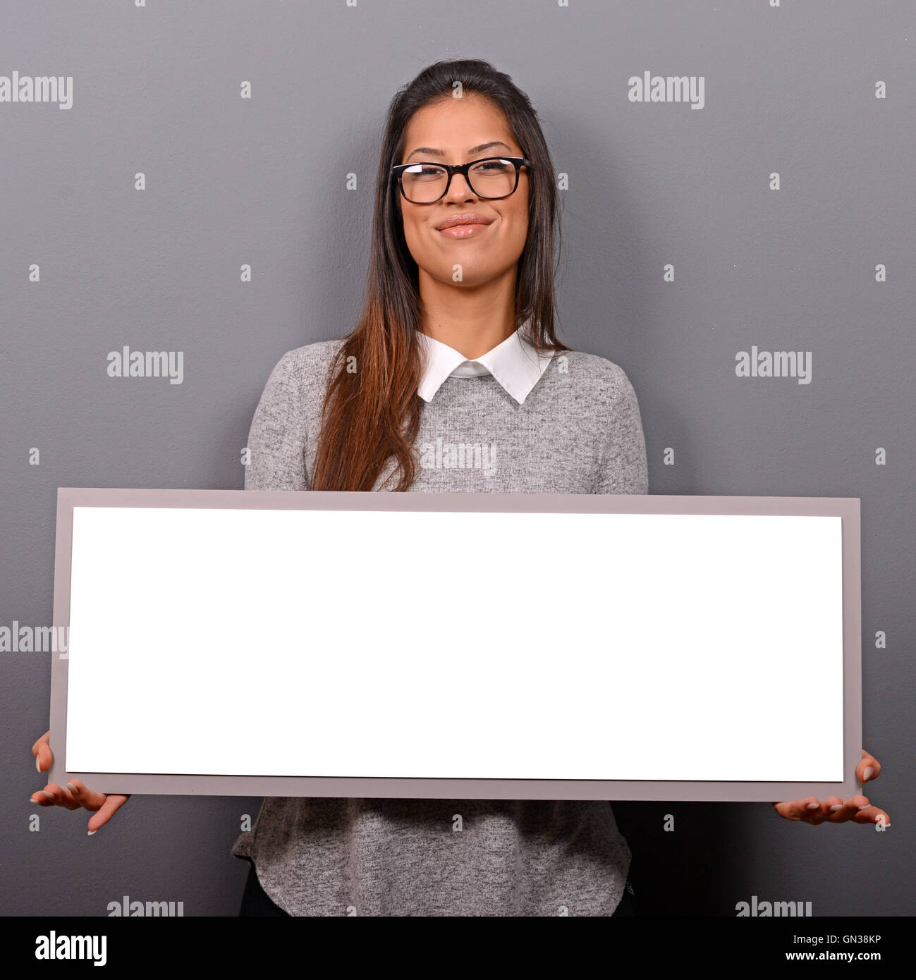 Portrait of smiling woman holding blank sign board.Studio portrait of ...