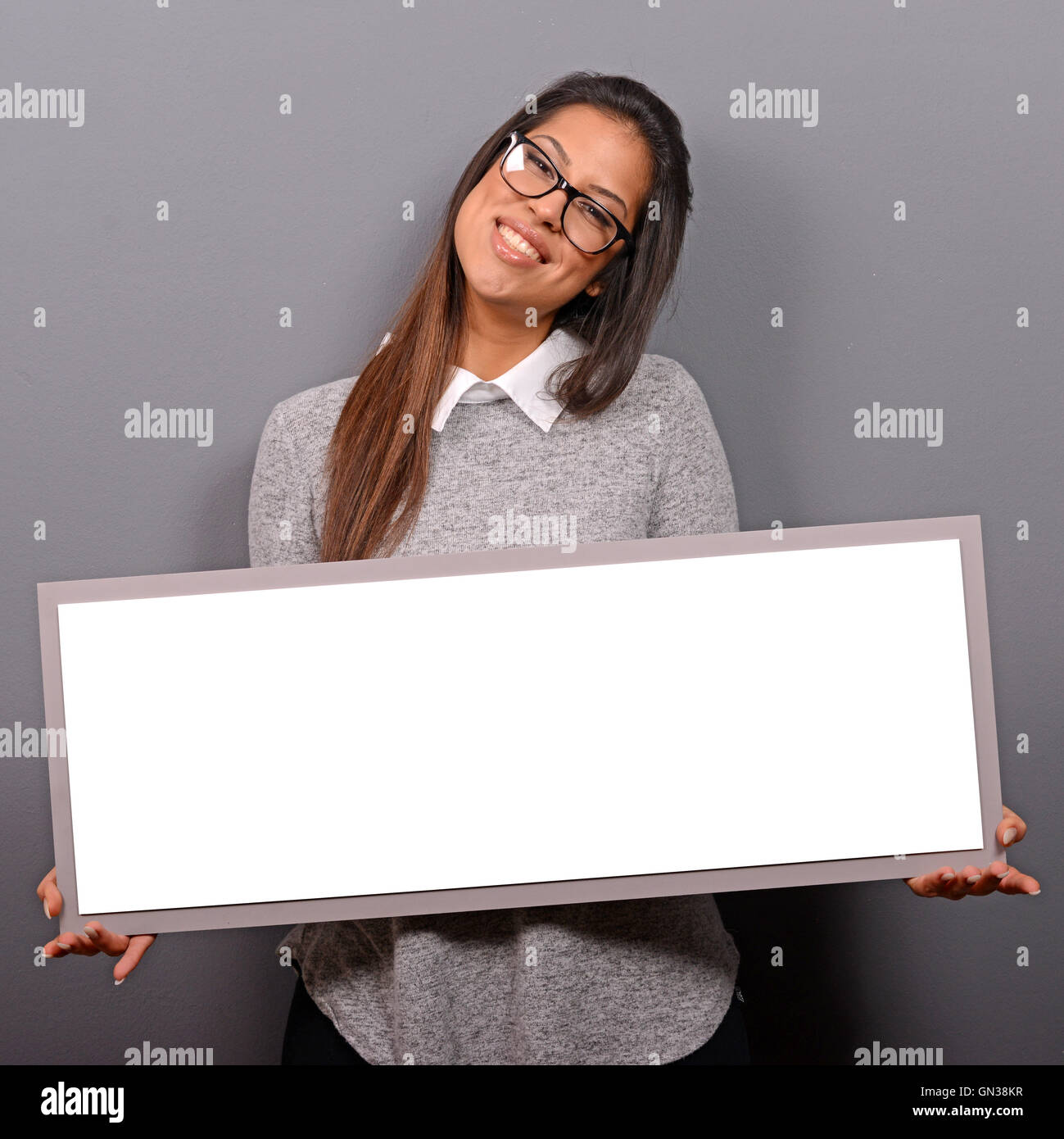 Portrait of smiling woman holding blank sign board.Studio portrait of ...