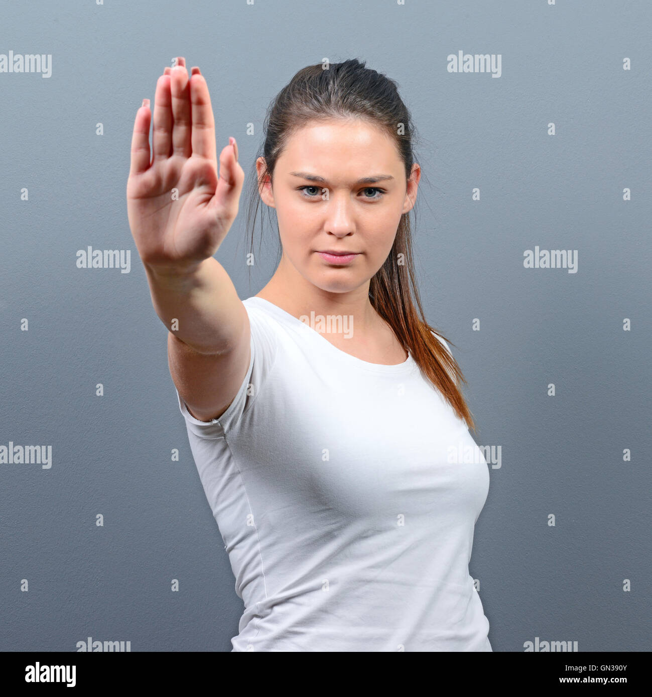 Portrait of woman showing stop with hand against gray background Stock ...