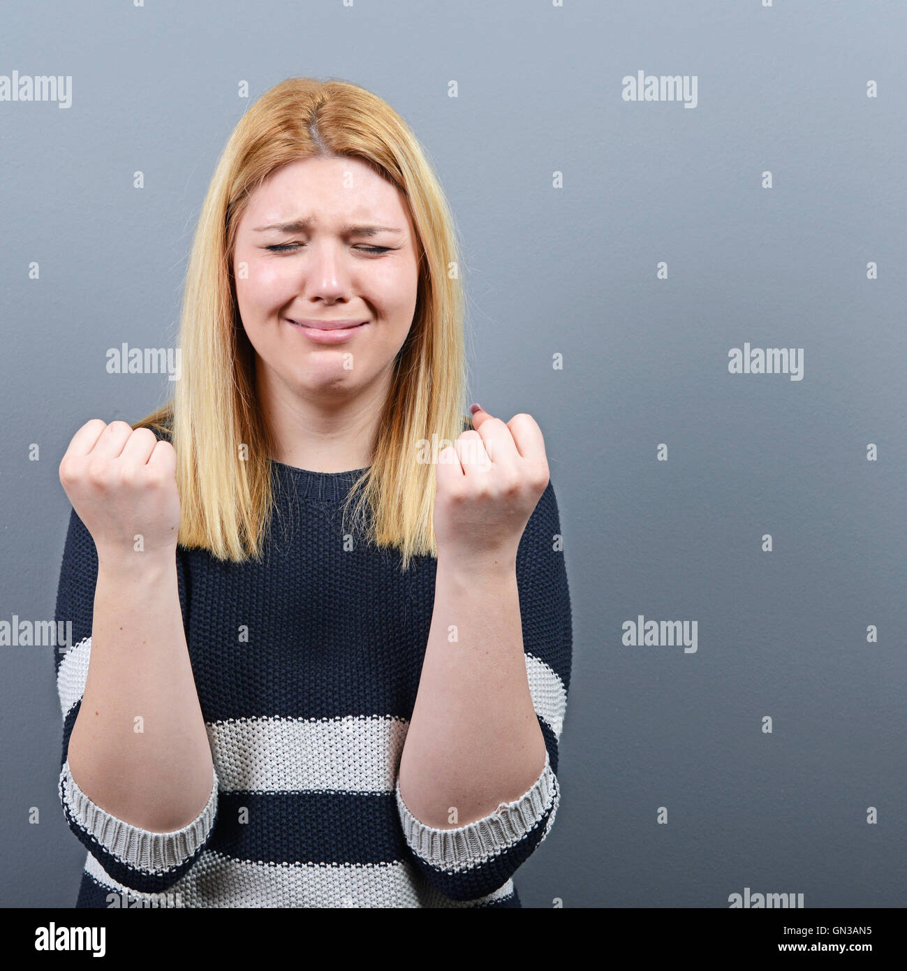 Desperate woman begging for mercy against gray background Stock Photo ...