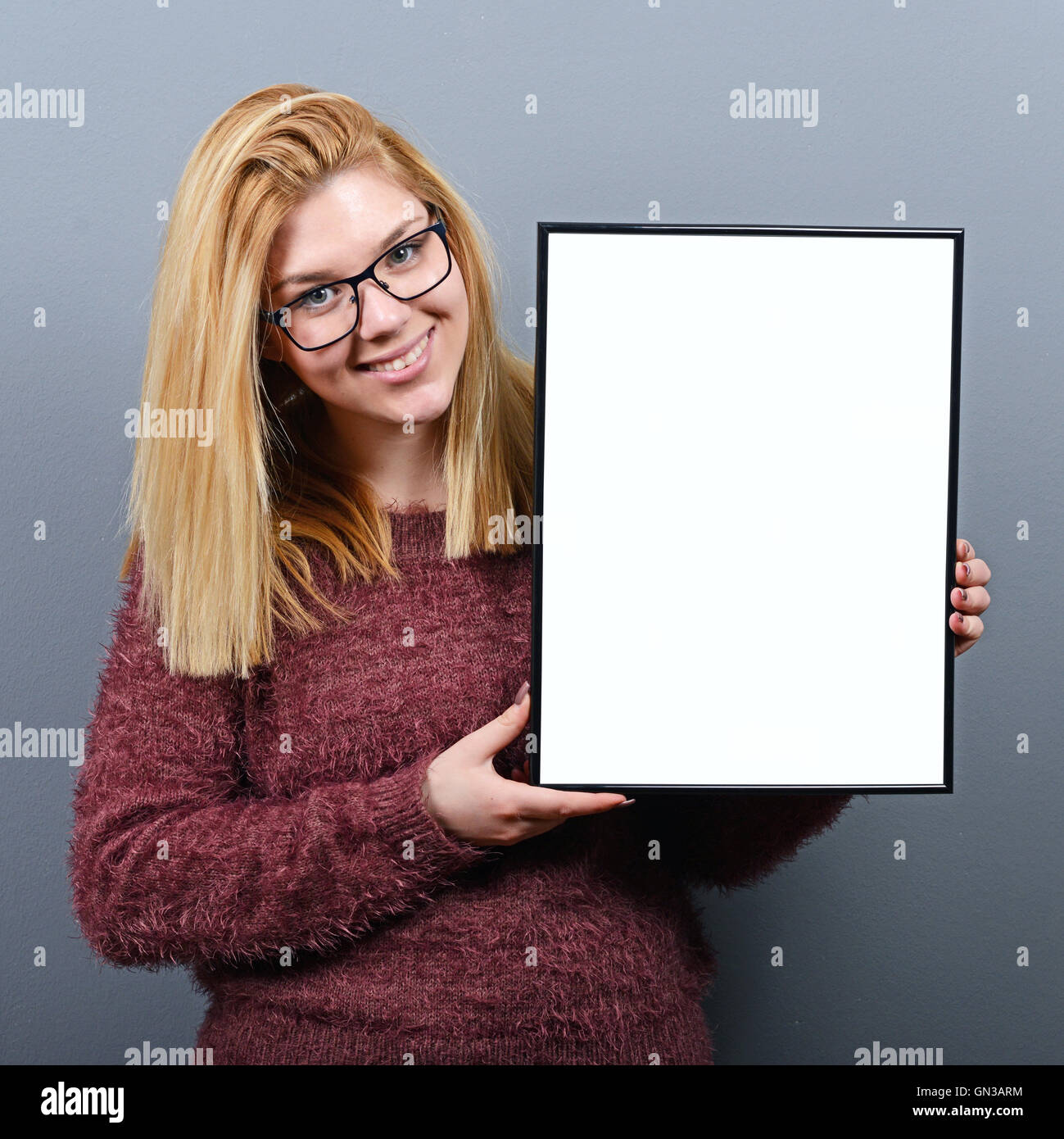 Portrait of smiling woman holding blank sign board.Studio portrait of ...