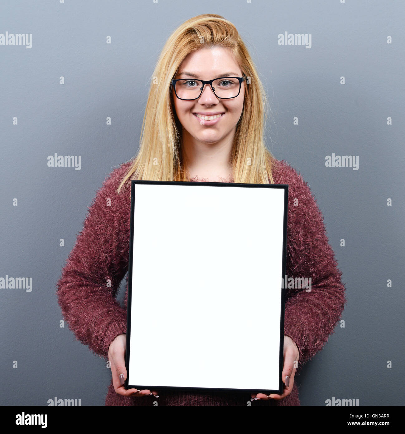 Portrait of smiling woman holding blank sign board.Studio portrait of ...