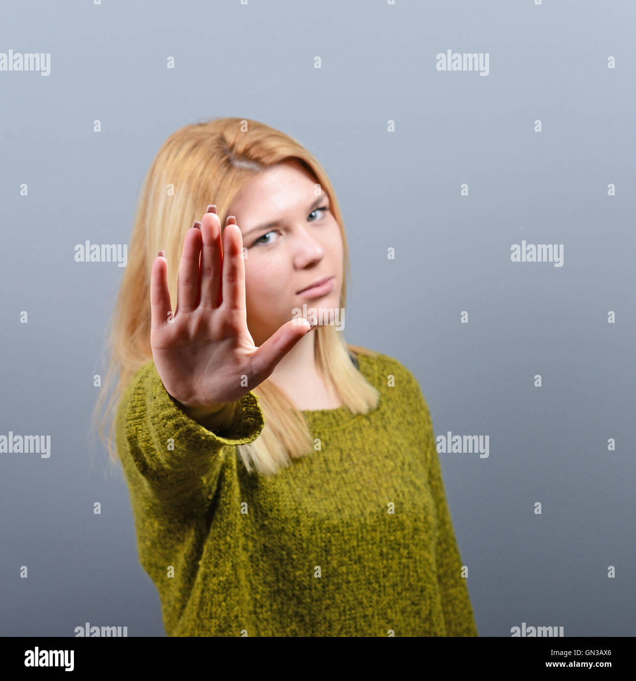 Portrait of woman showing stop with hand against gray background Stock ...