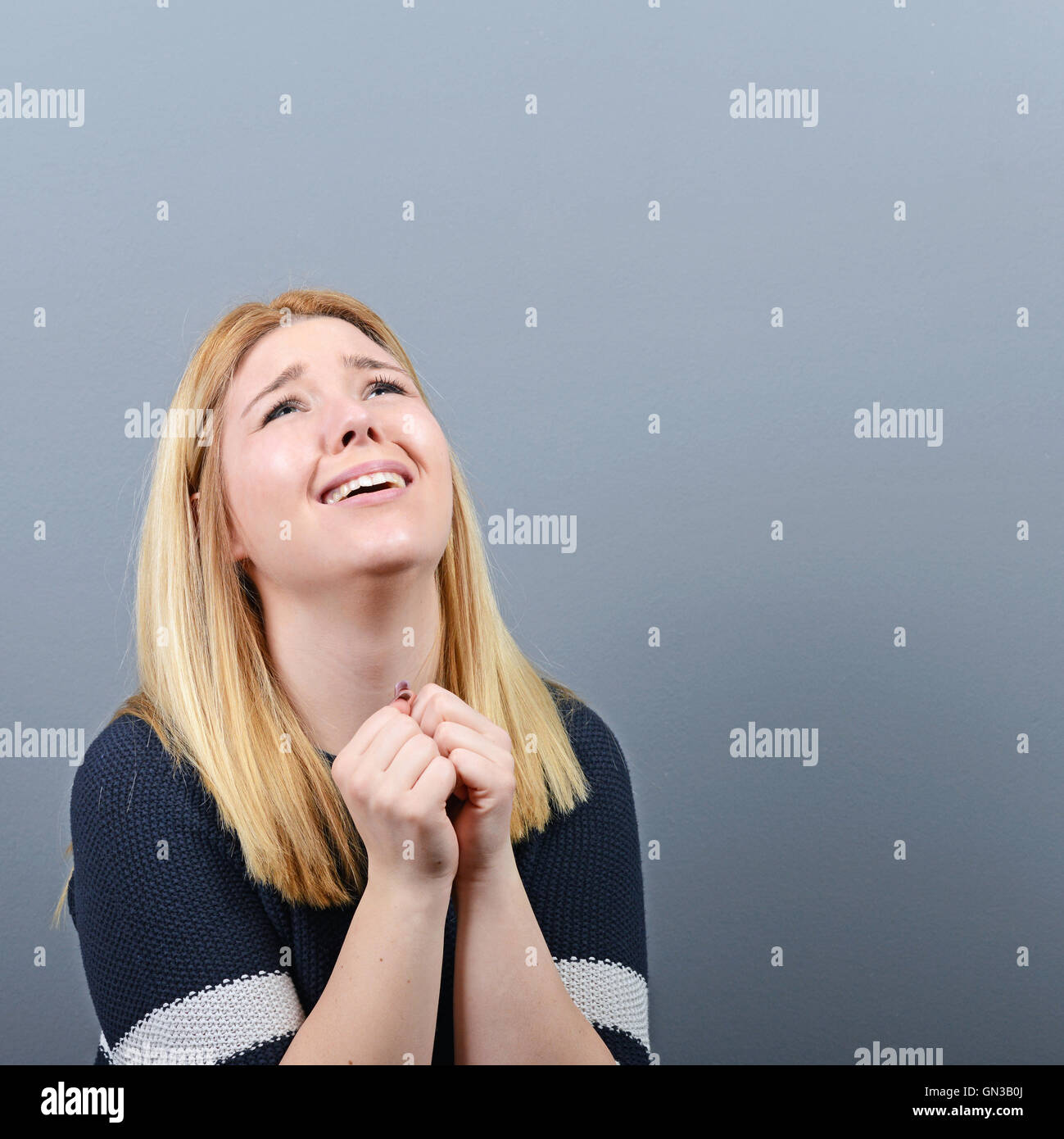 Woman praying about something or begging for mercy against gray ...