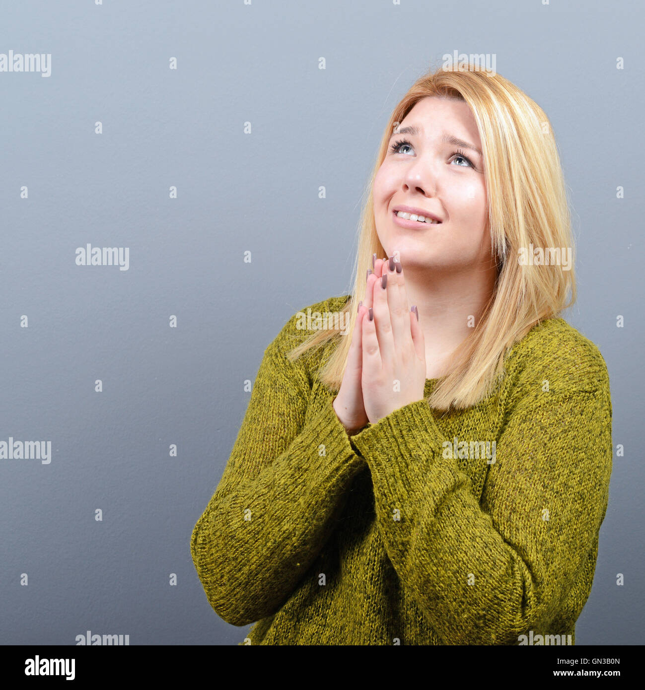 Woman praying about something or begging for mercy against gray ...