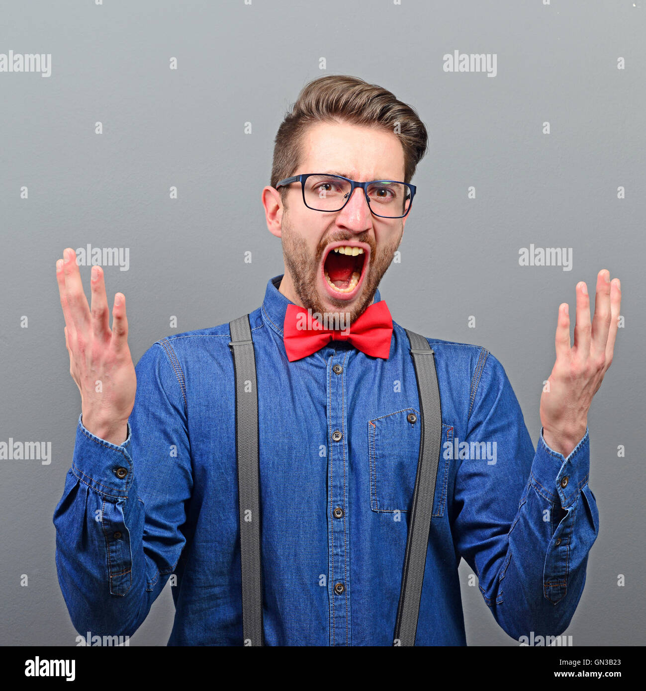Portrait of a angry man screaming against gray background Stock Photo ...
