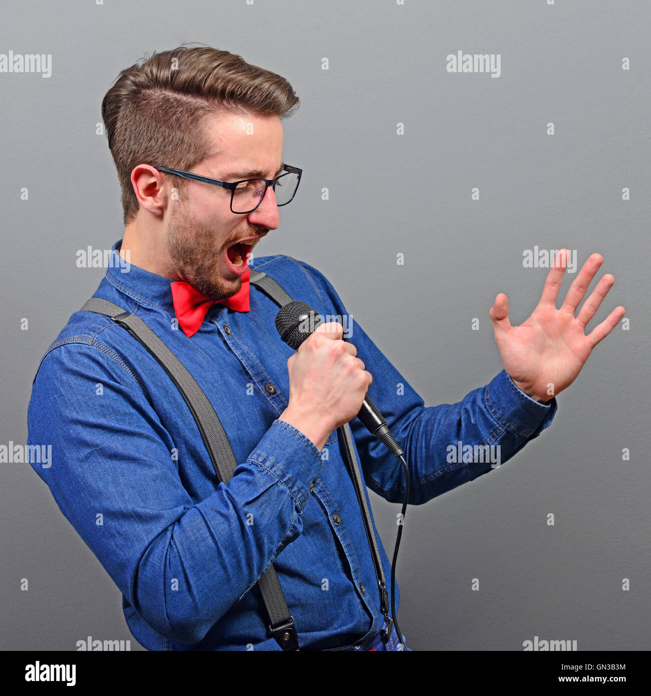Portrait of attractive young man singer against gray background Stock ...