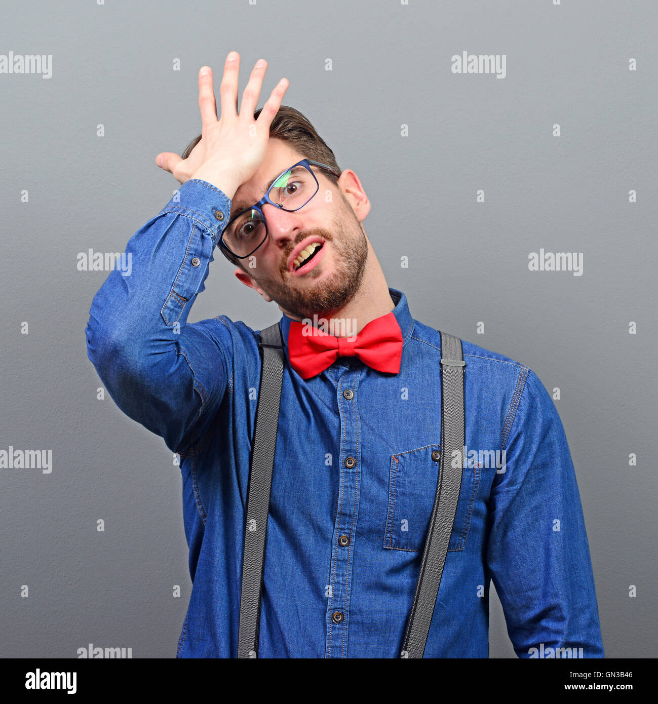 Portrait of forgetful man against gray background Stock Photo - Alamy