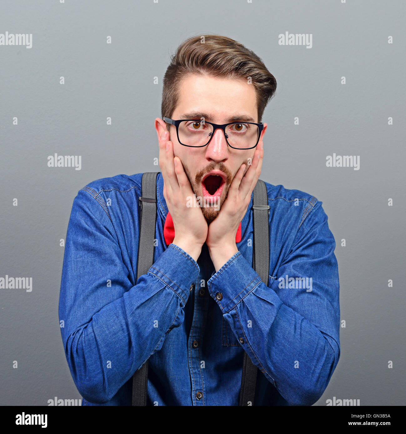 Portrait of shocked man against gray background Stock Photo - Alamy
