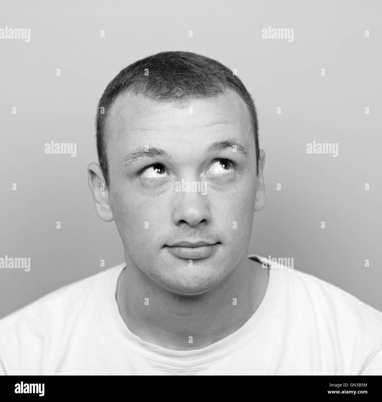 Portrait of man thinking and looking up against green background Stock ...