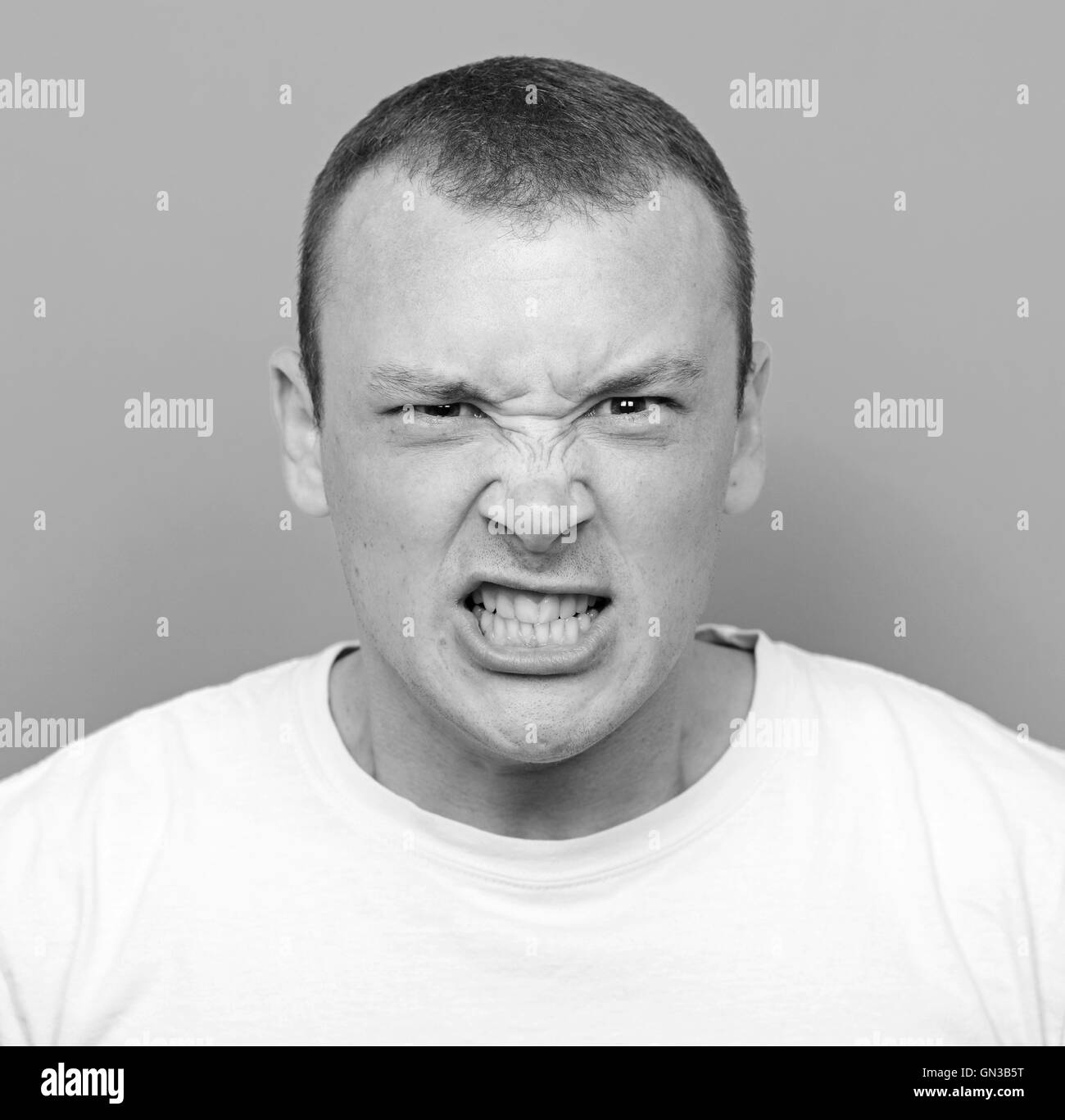 Portrait of angry man screaming and pulling hair against red background ...