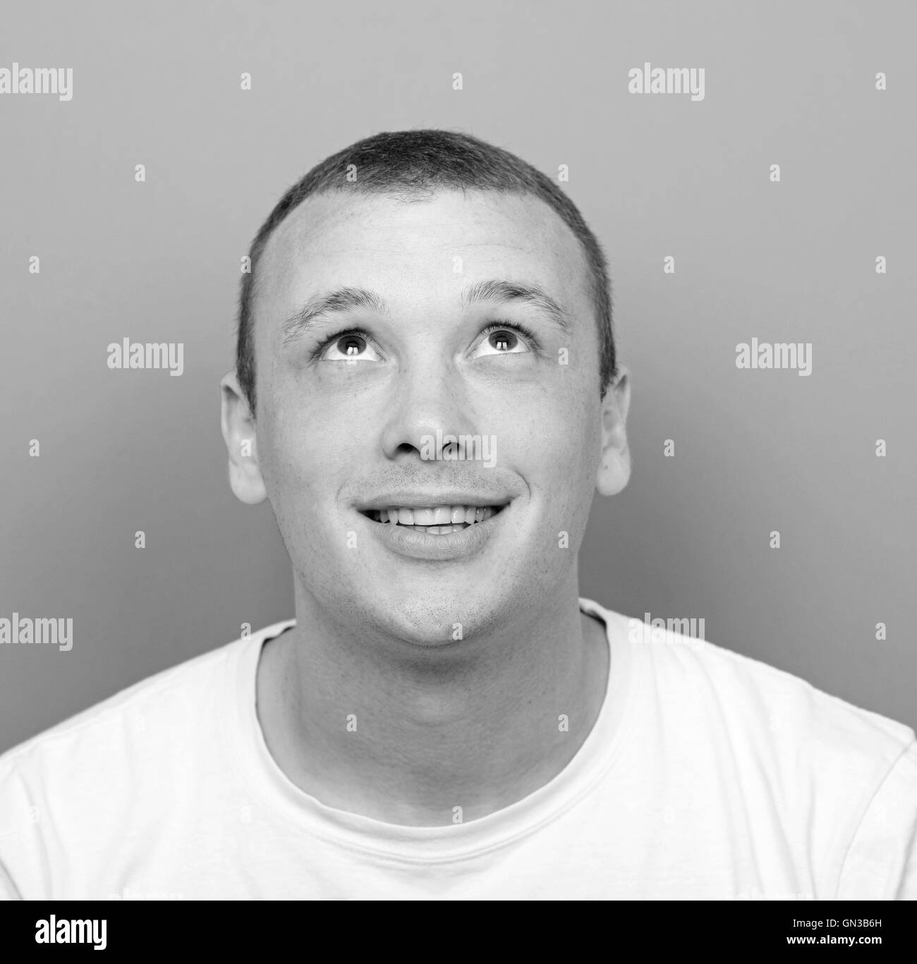 Portrait of happy young man looking up Stock Photo - Alamy