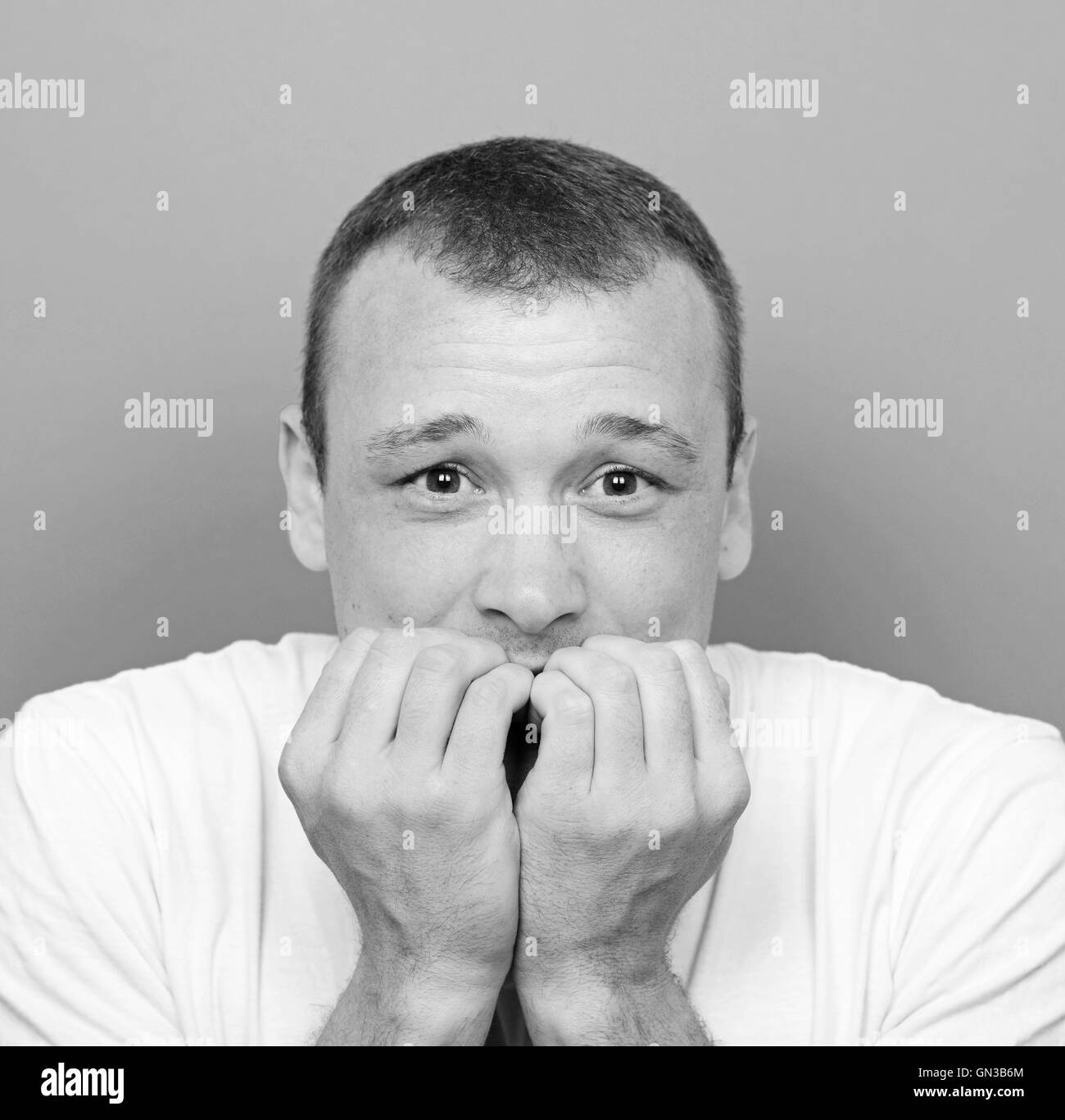 Portrait of man biting nails against yellow background Stock Photo - Alamy