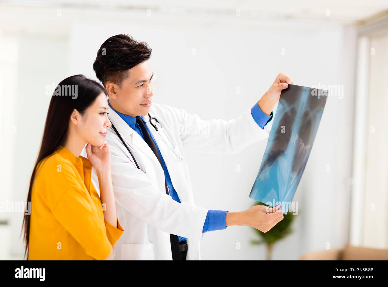 young doctor looking at patient's x-ray film Stock Photo - Alamy