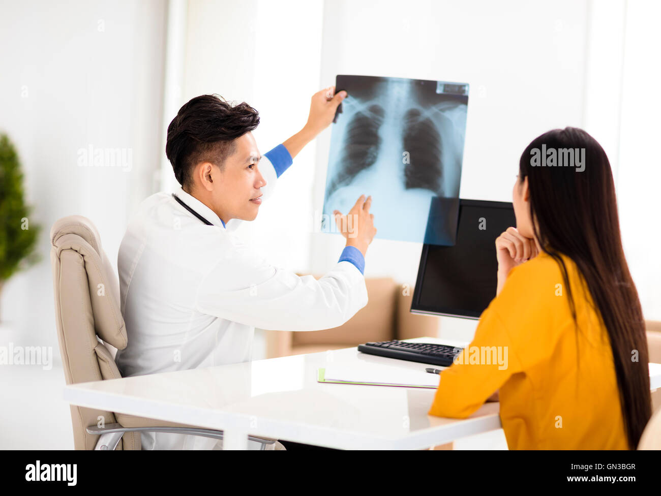 young doctor looking at patient's x-ray film Stock Photo - Alamy