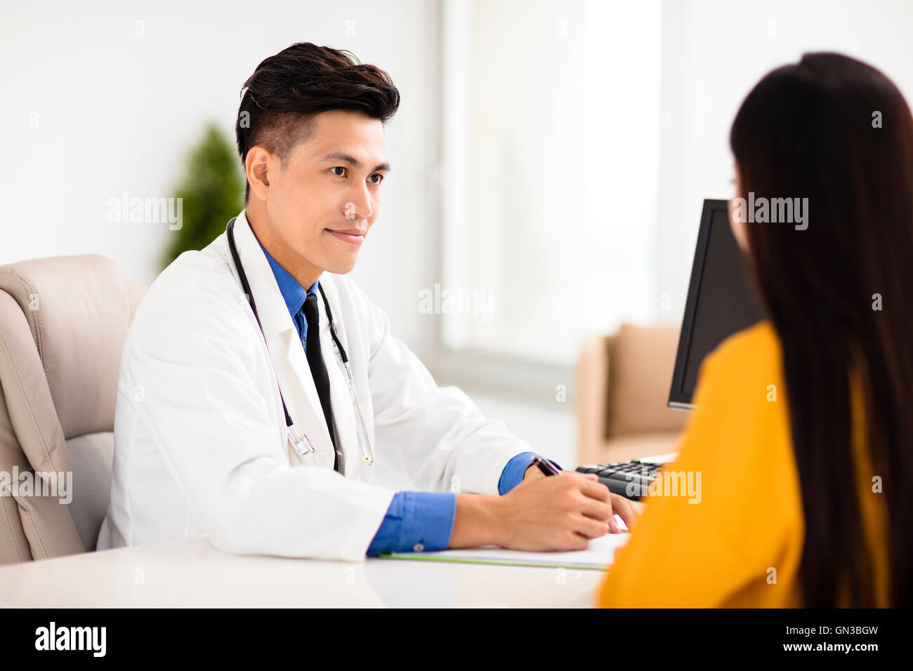 young doctor talking with his patient in office Stock Photo - Alamy