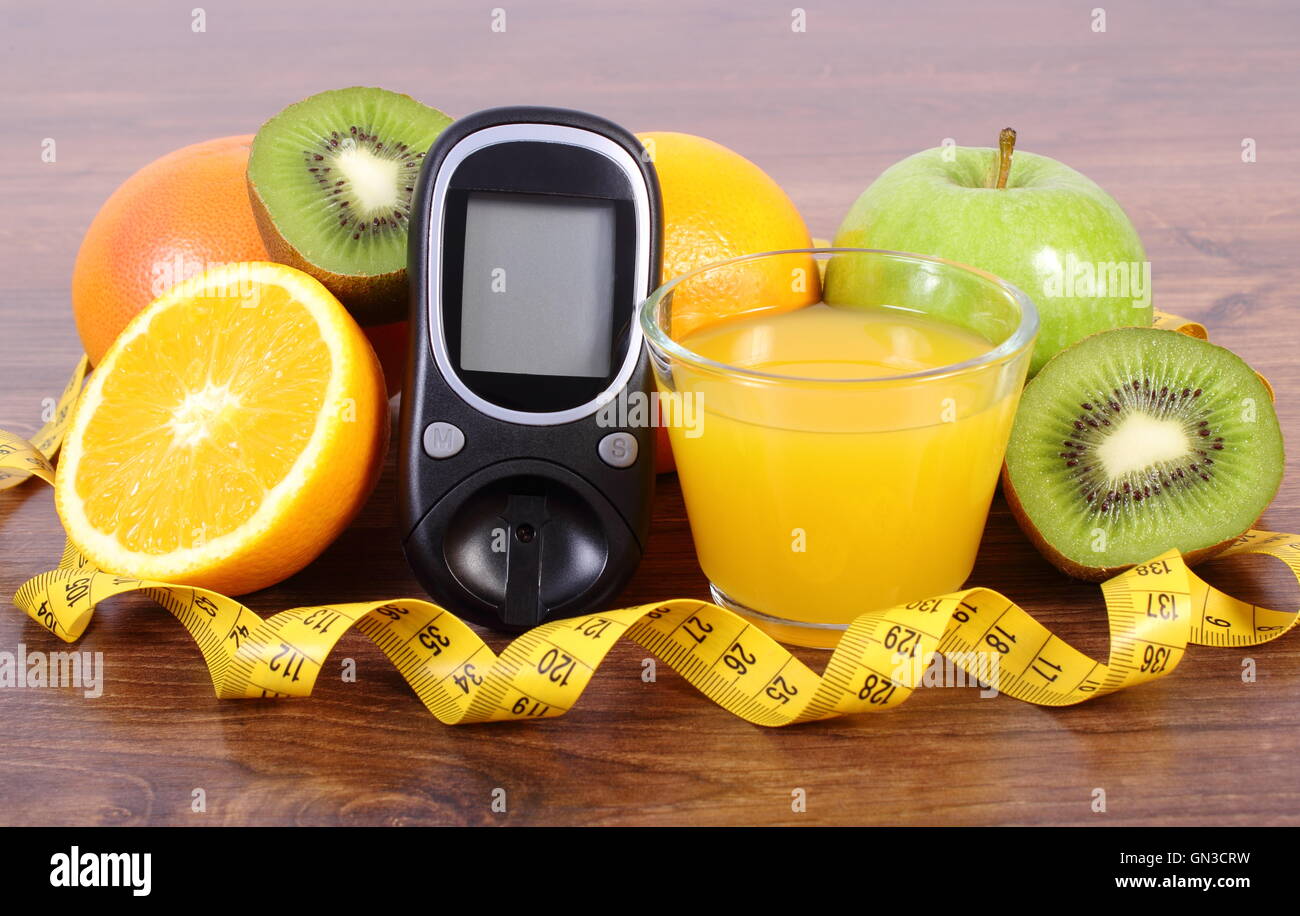 Glucose meter, fresh ripe fruits, glass of juice and tape measure ...