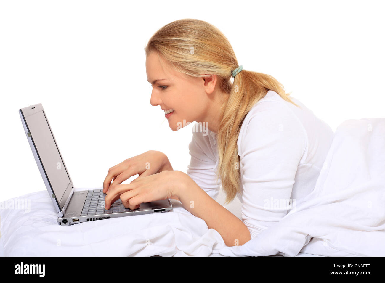 Lying in bed with computer Stock Photo - Alamy