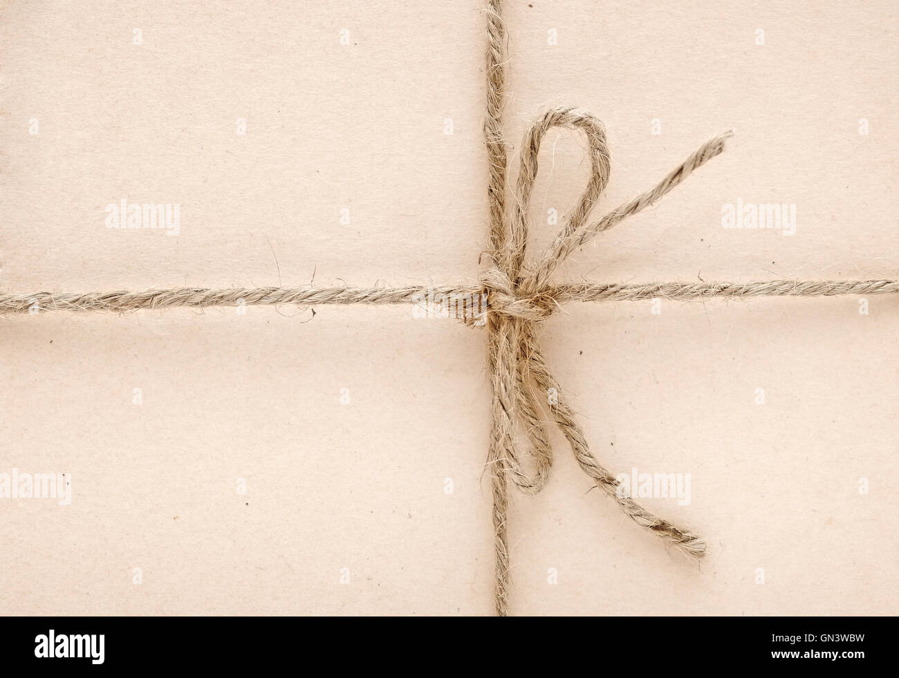 String tied in a bow on a brown paper Stock Photo - Alamy