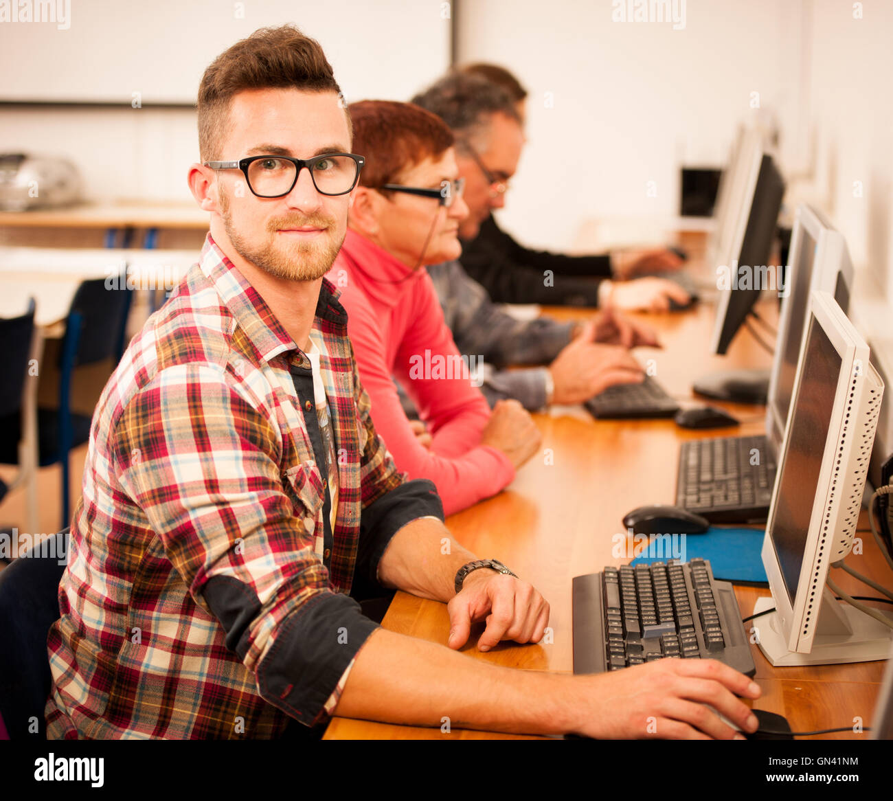 Group of adults learning computer skills. Intergenerational transfer of ...