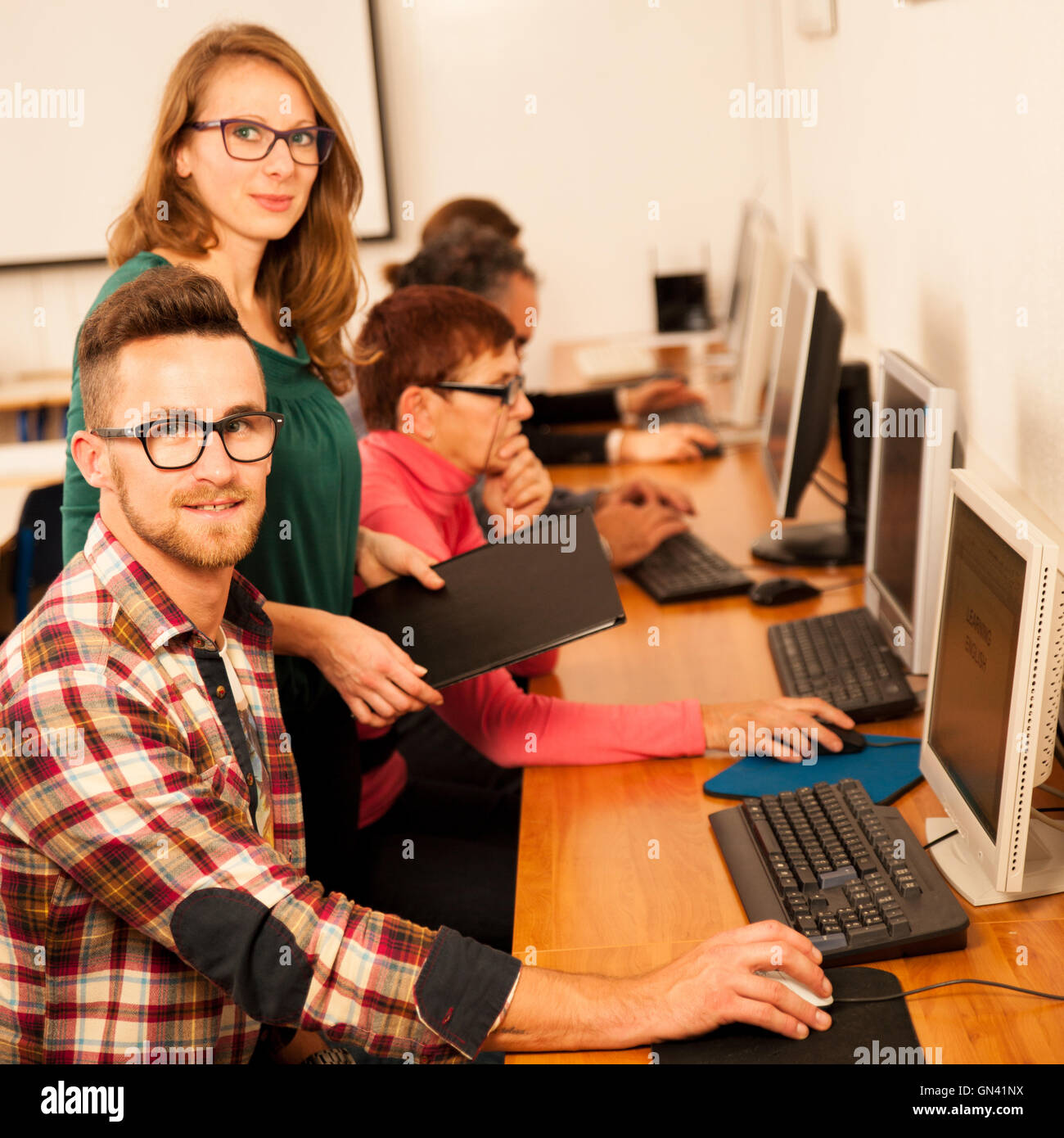 Group of adults learning computer skills. Intergenerational transfer of ...