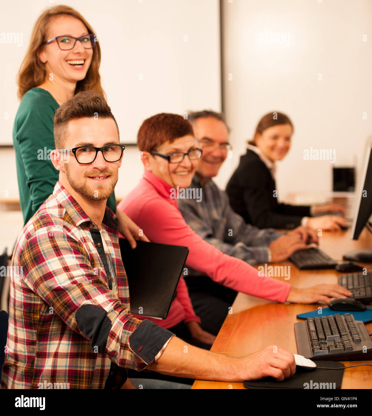 Group of adults learning computer skills. Intergenerational transfer of ...