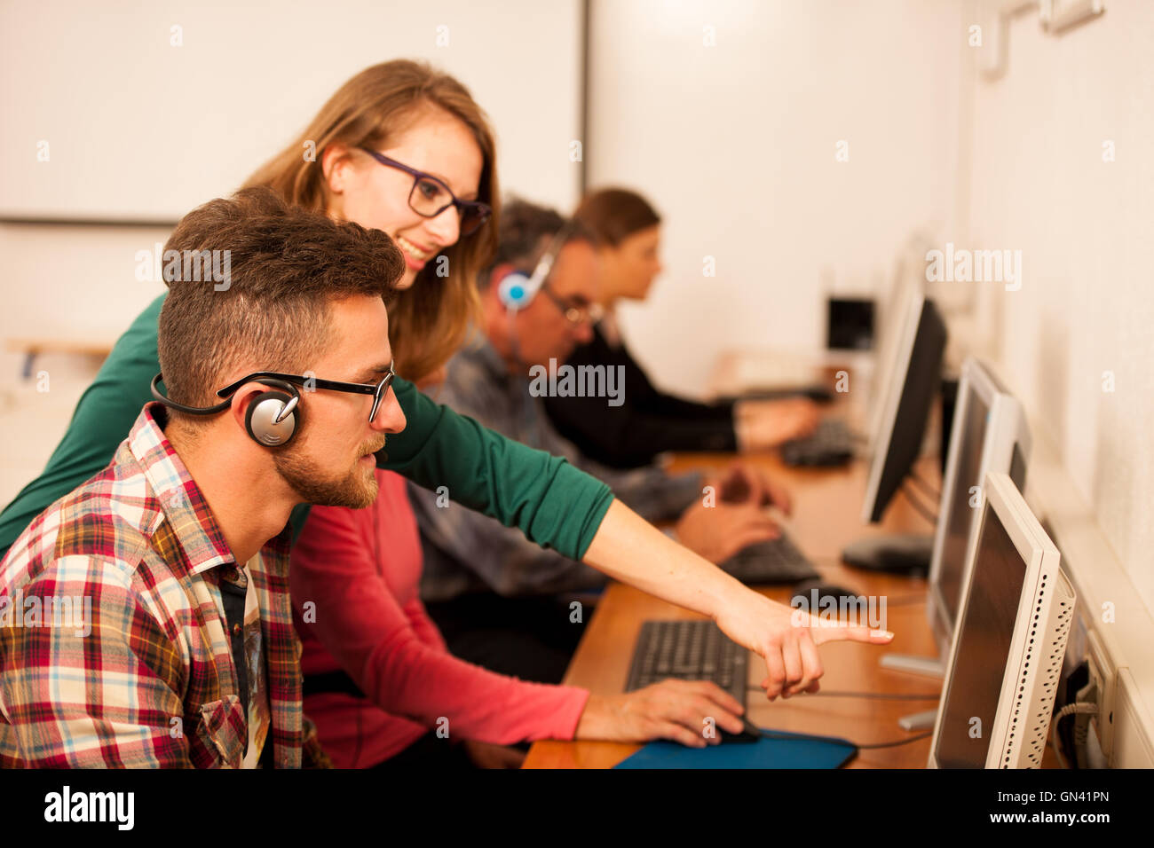 Group of adults learning computer skills. Intergenerational transfer of ...