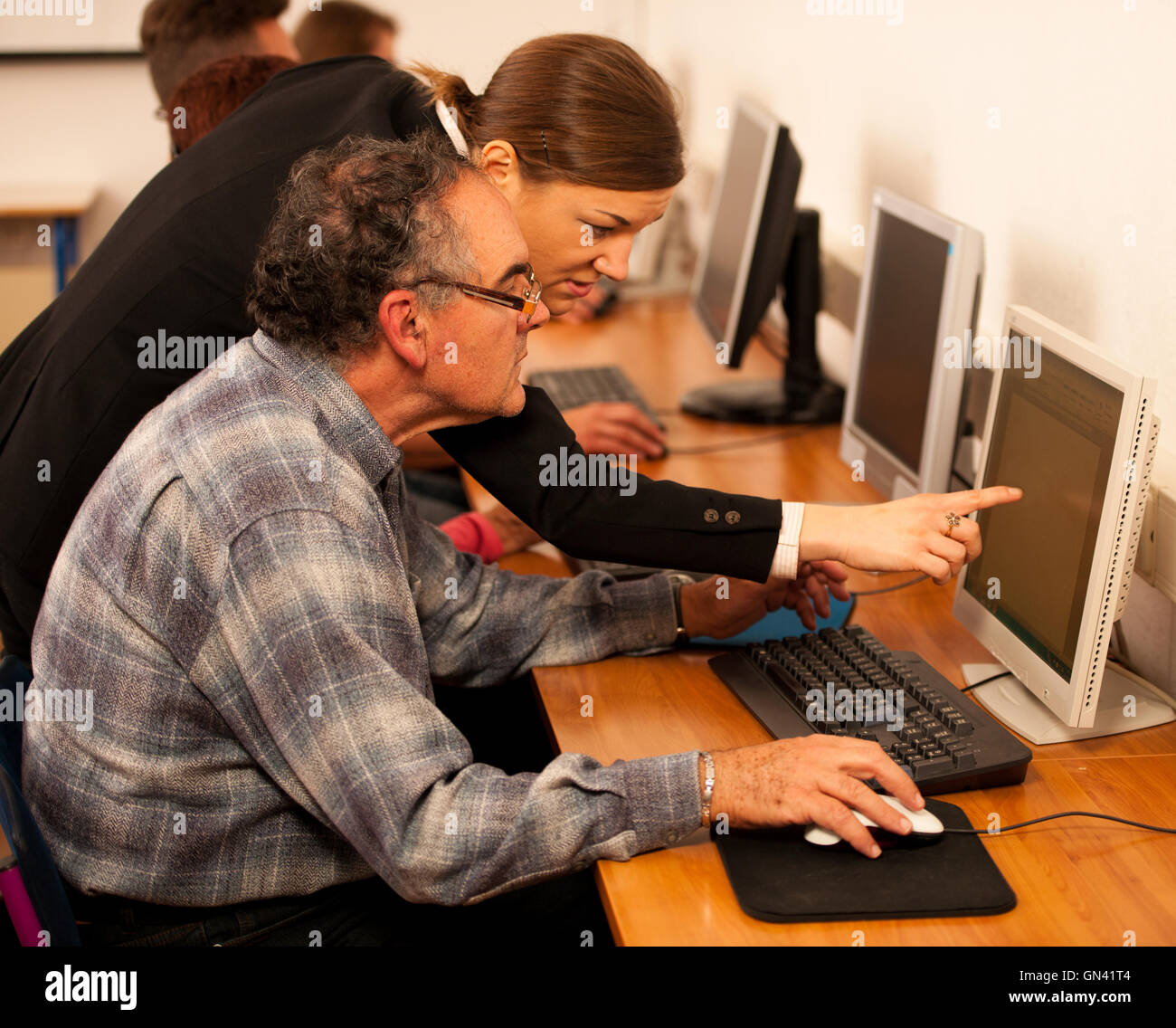 Group of adults learning computer skills. Intergenerational transfer of ...