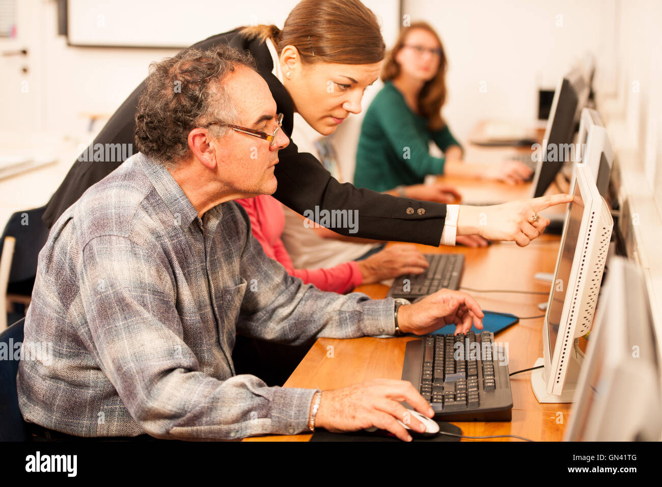 Group of adults learning computer skills. Intergenerational transfer of ...