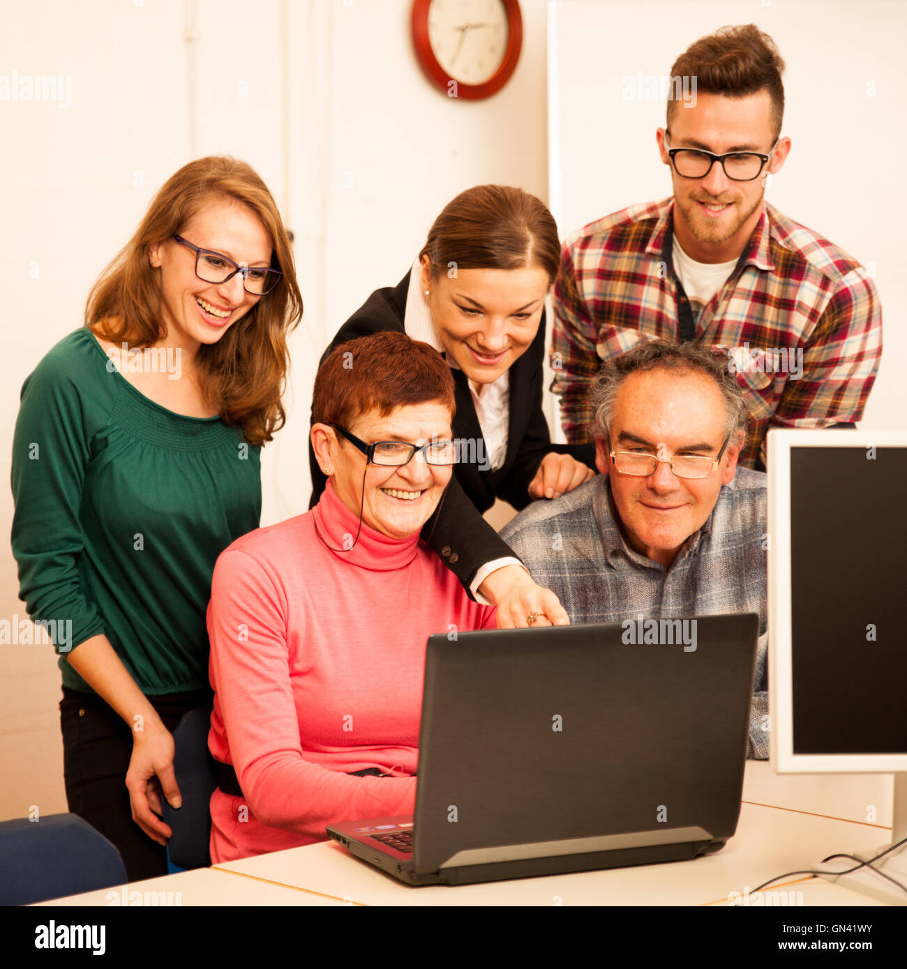 Group of adults learning computer skills. Intergenerational transfer of ...