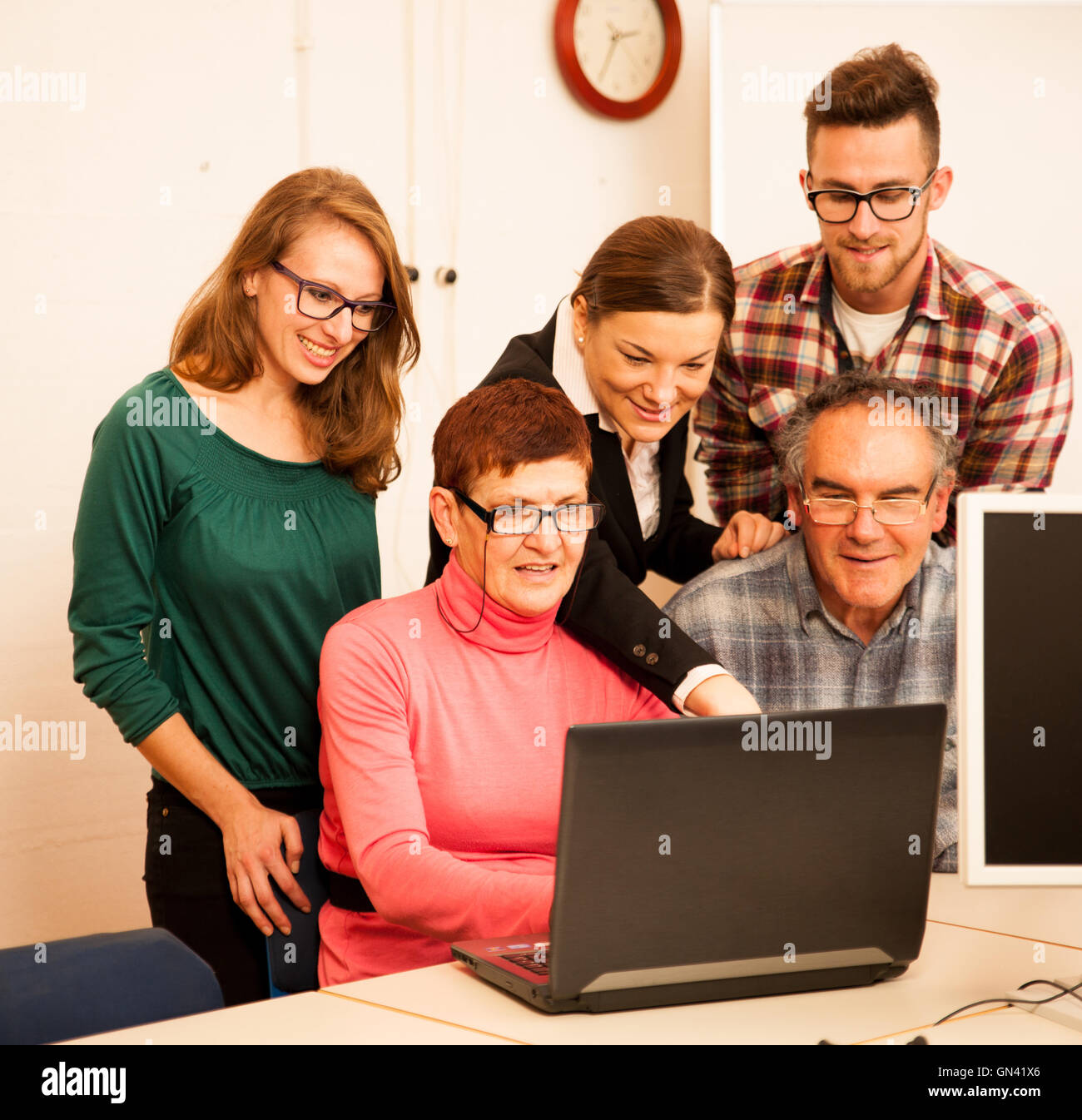 Group of adults learning computer skills. Intergenerational transfer of ...