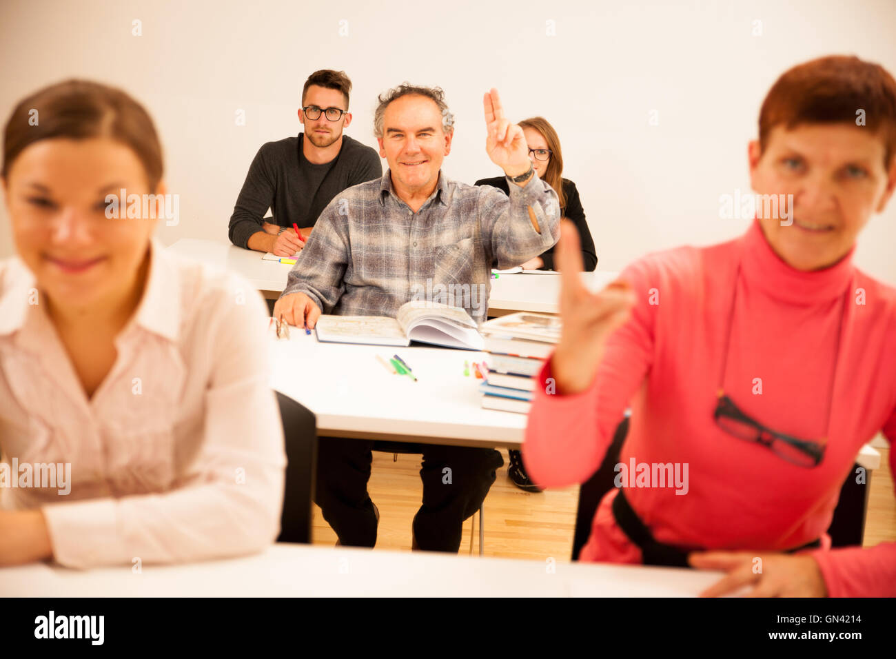 Group of people of different age sitting in classroom and attending a ...