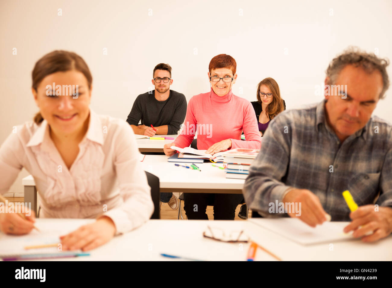 Group of people of different age sitting in classroom and attending a ...