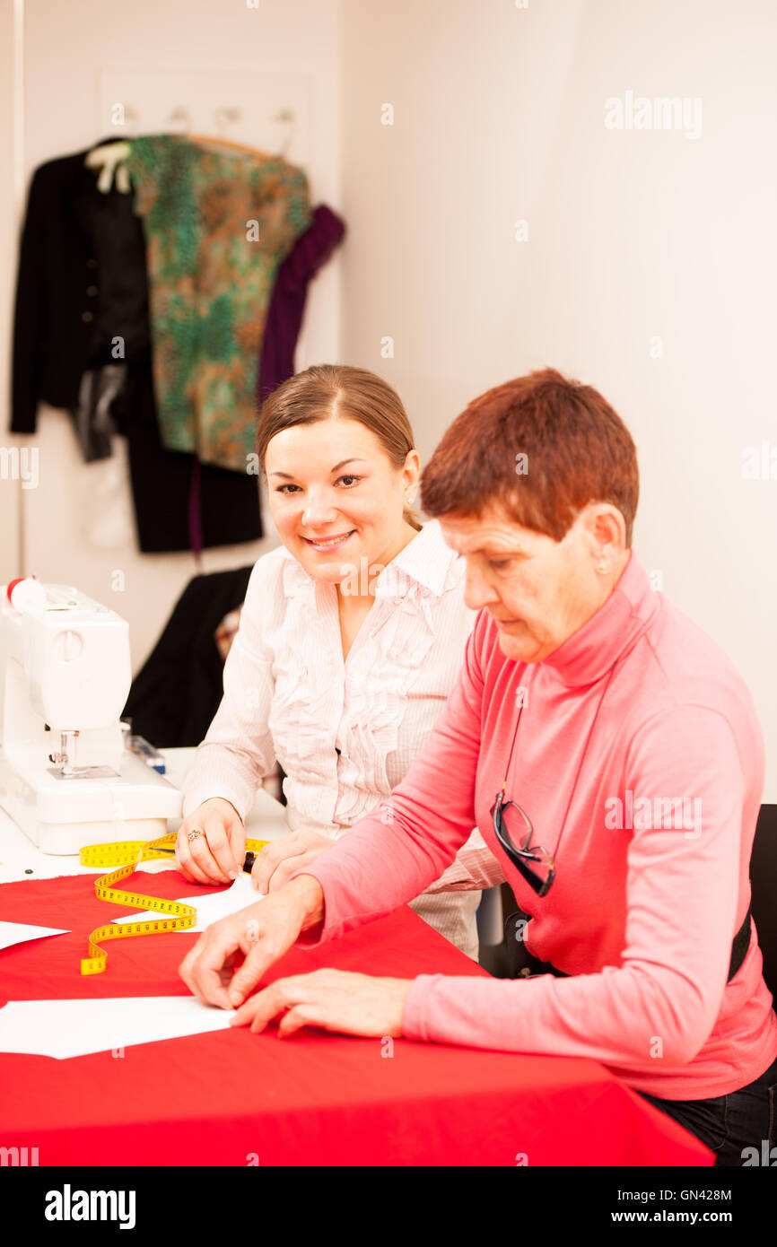 Three women are sewing on handcraft workshop. They are teaching each ...