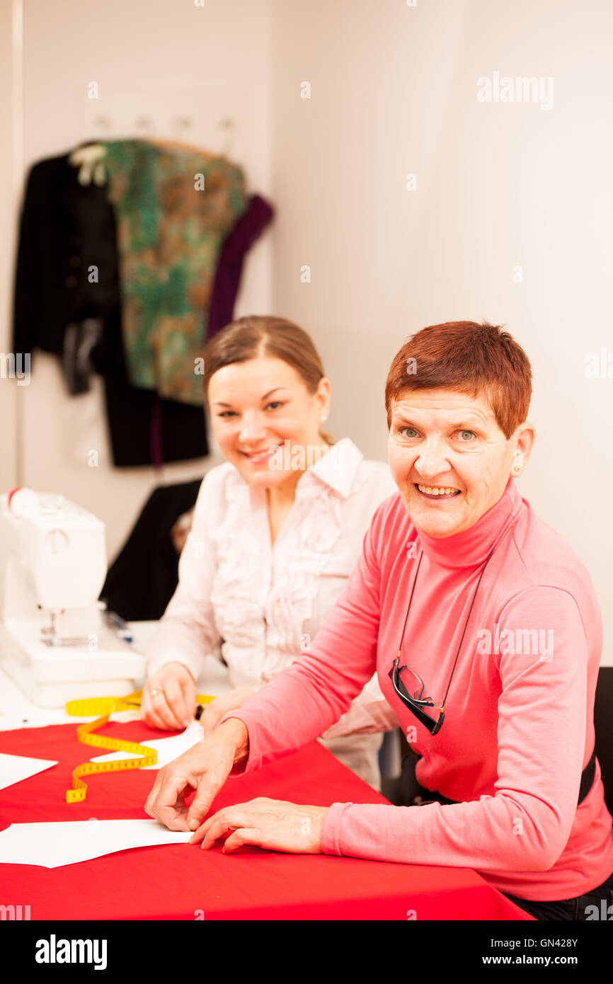 Three women are sewing on handcraft workshop. They are teaching each ...