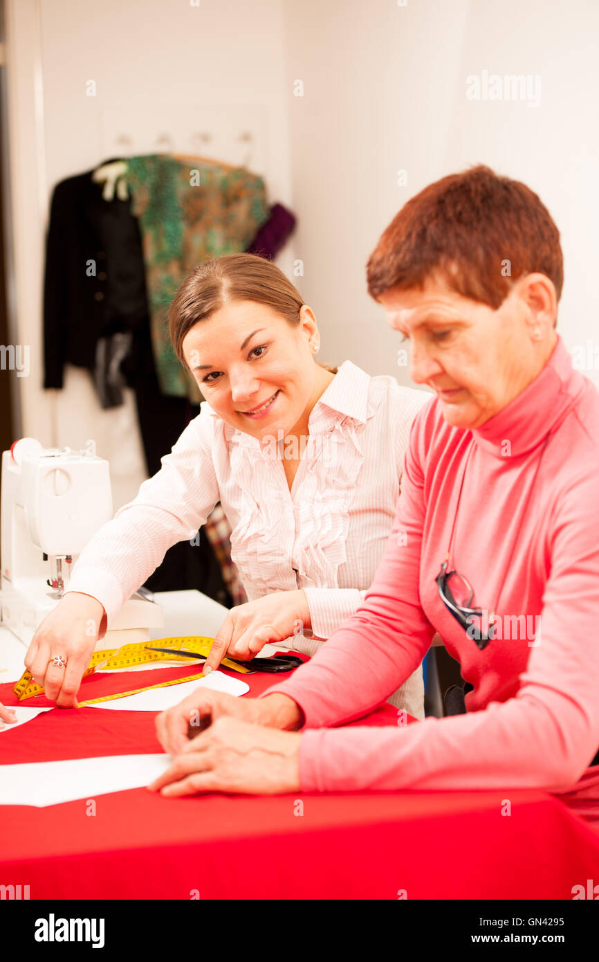 Three women are sewing on handcraft workshop. They are teaching each ...