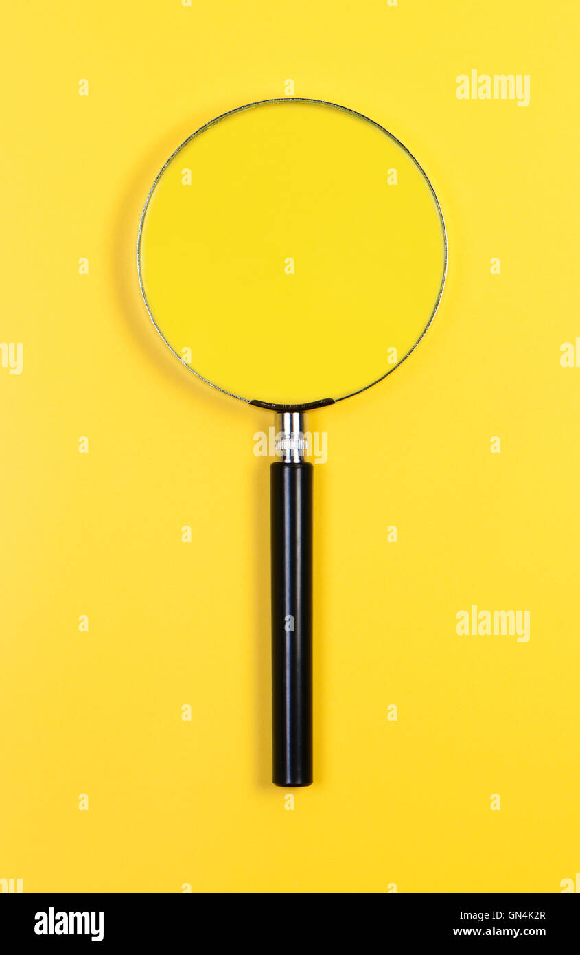 Magnifier on yellow background Stock Photo - Alamy