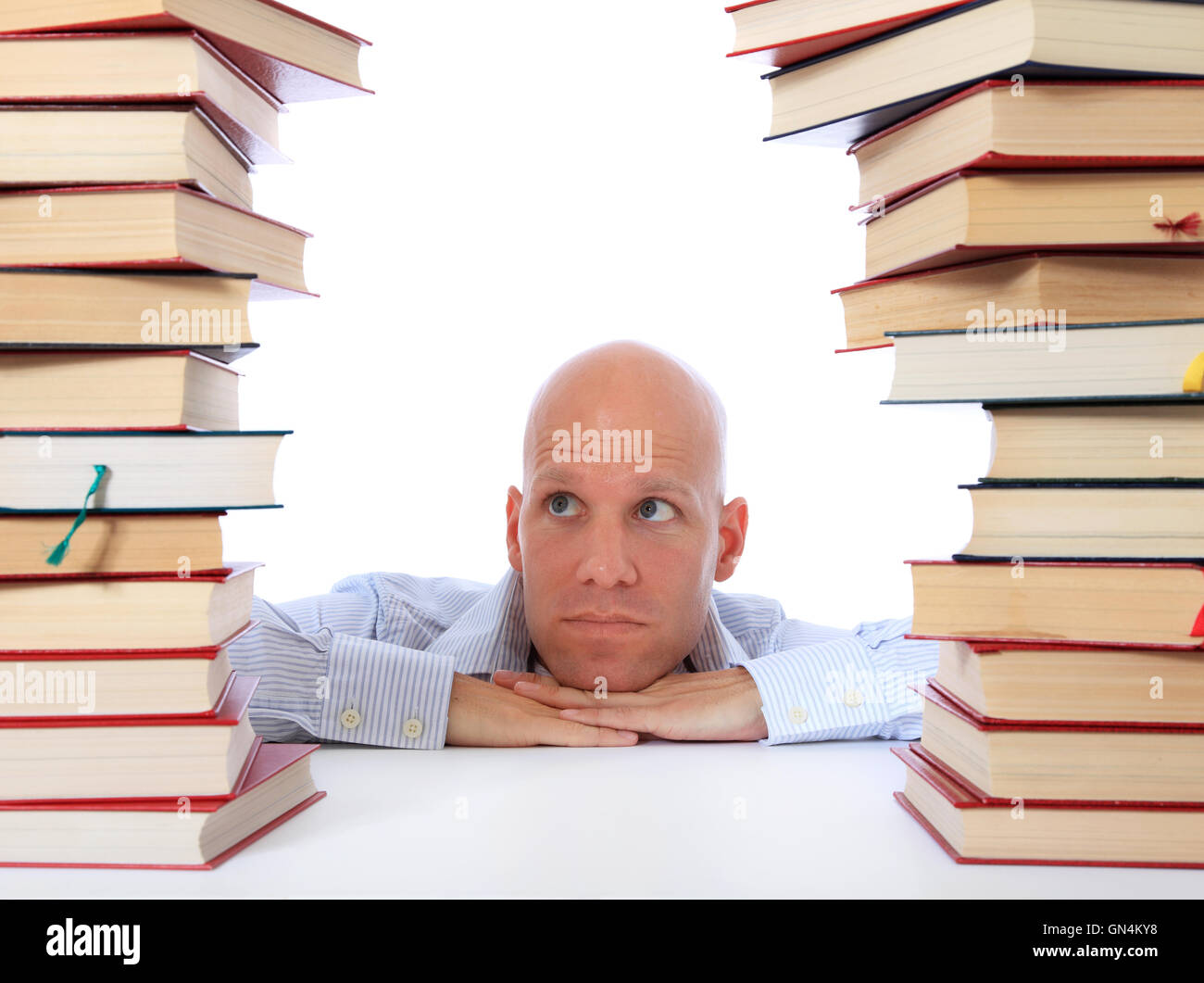 Man between two piles of books Stock Photo - Alamy