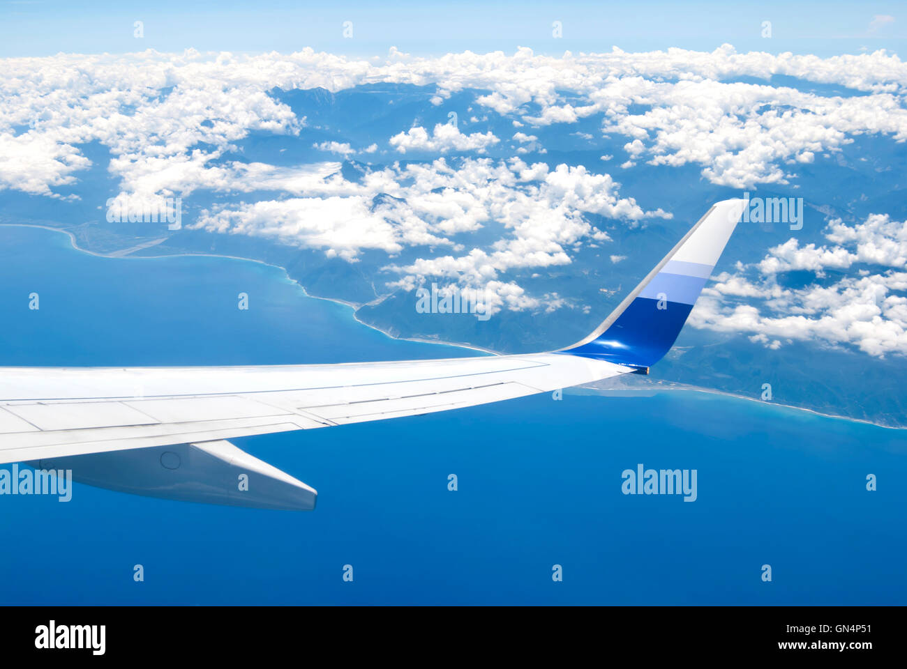 Airplane fly over land and ocean Stock Photo - Alamy
