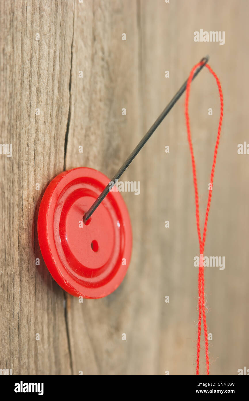 Buttons with needle and thread Stock Photo - Alamy