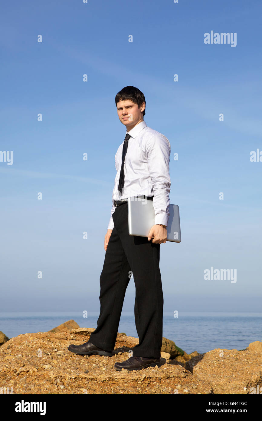 Man near sea wiwth laptop Stock Photo - Alamy