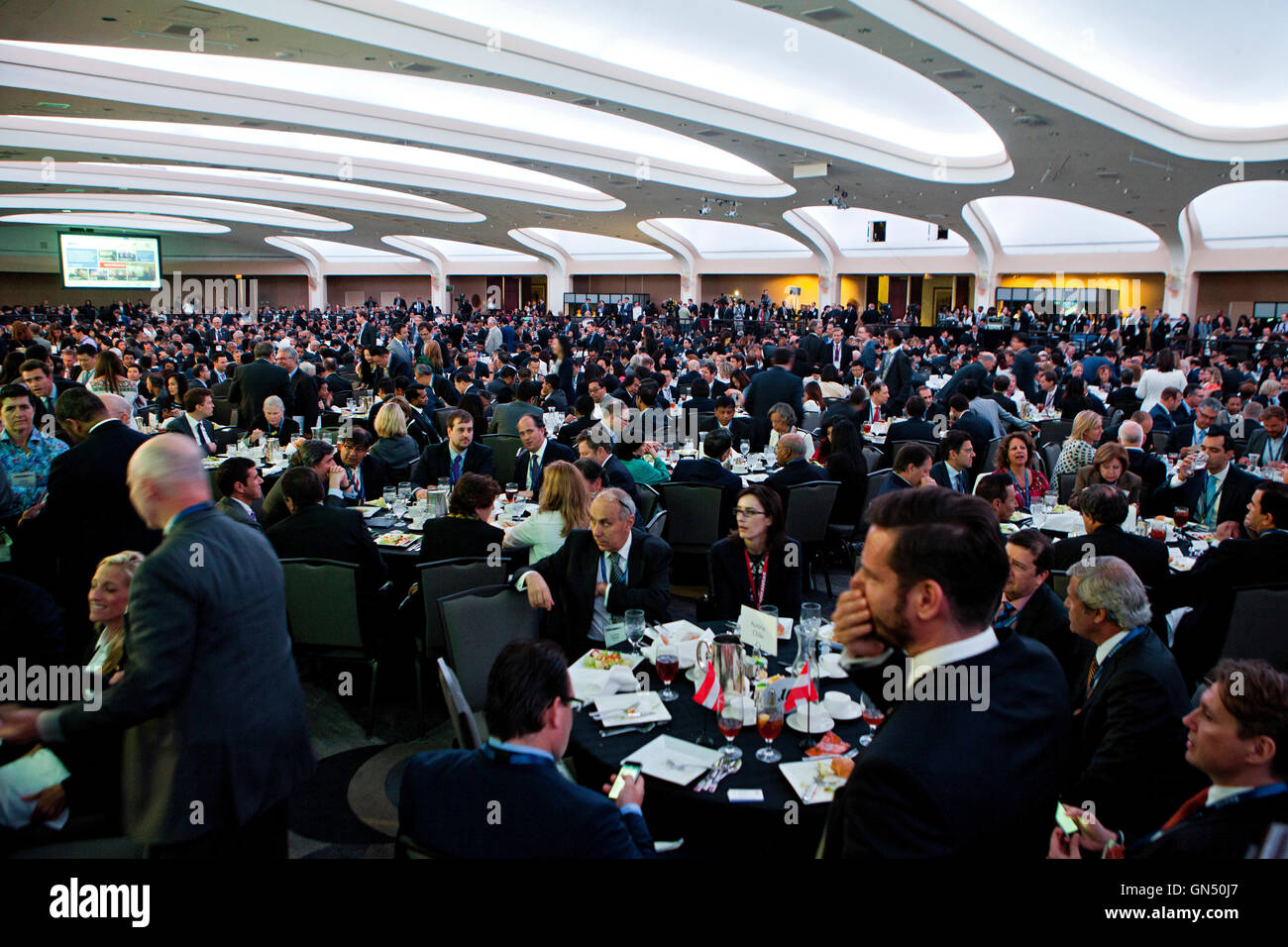 Guests seated at tables during an event in a large banquet room in the ...