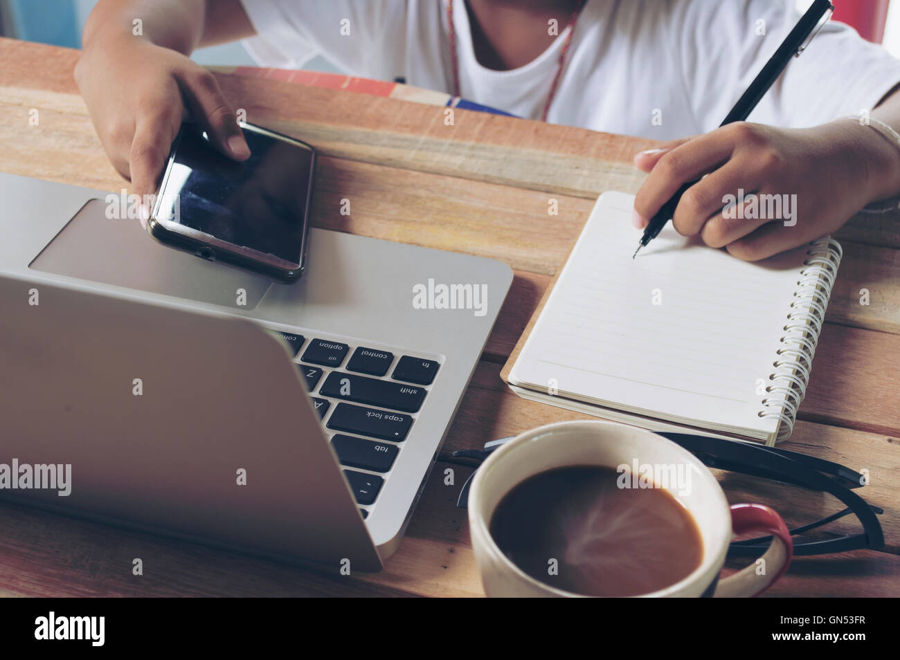 Kids doing homework by Internet with laptop,phone,notepad on wooden ...