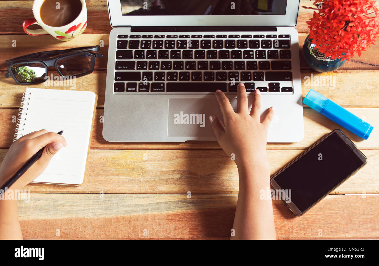 Kids doing homework by Internet with laptop,phone,notepad on wooden ...